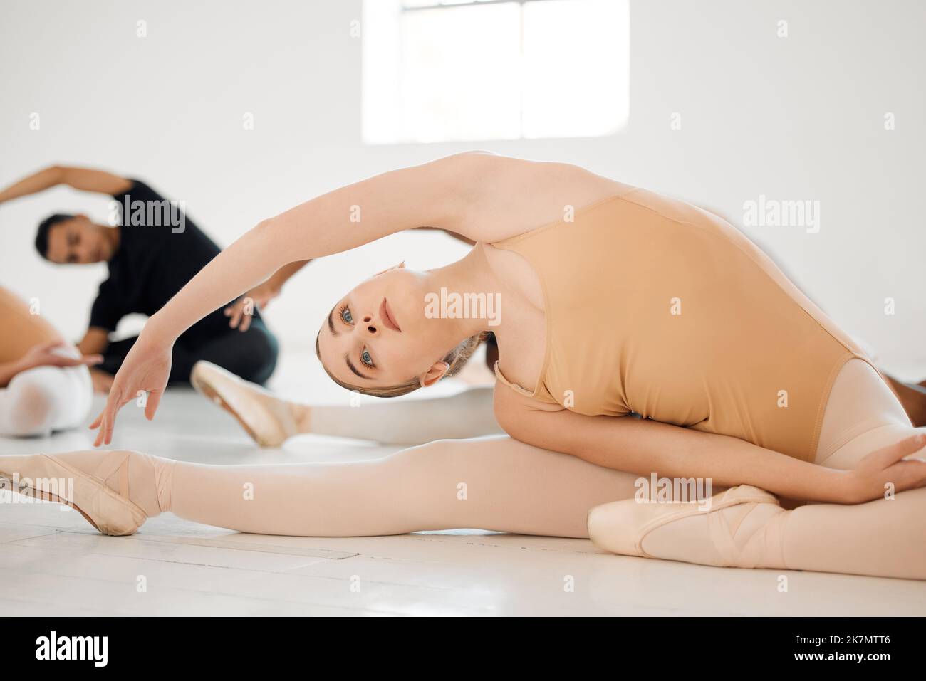 Everything living has a rhythm. a young group of ballerinas stretching ...