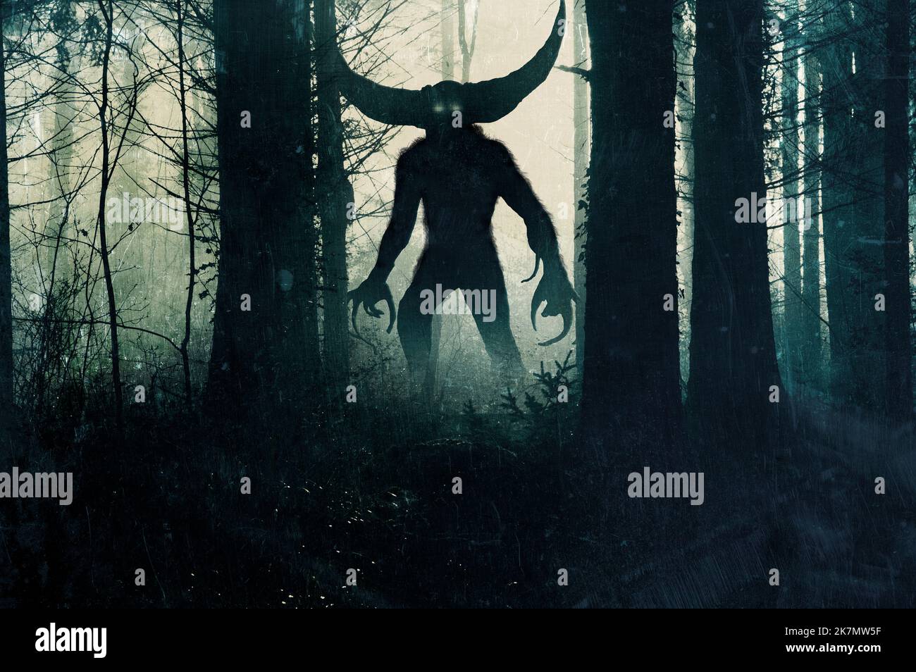 A horror demonic monster. With glowing eyes and horns. Silhouetted in a ...