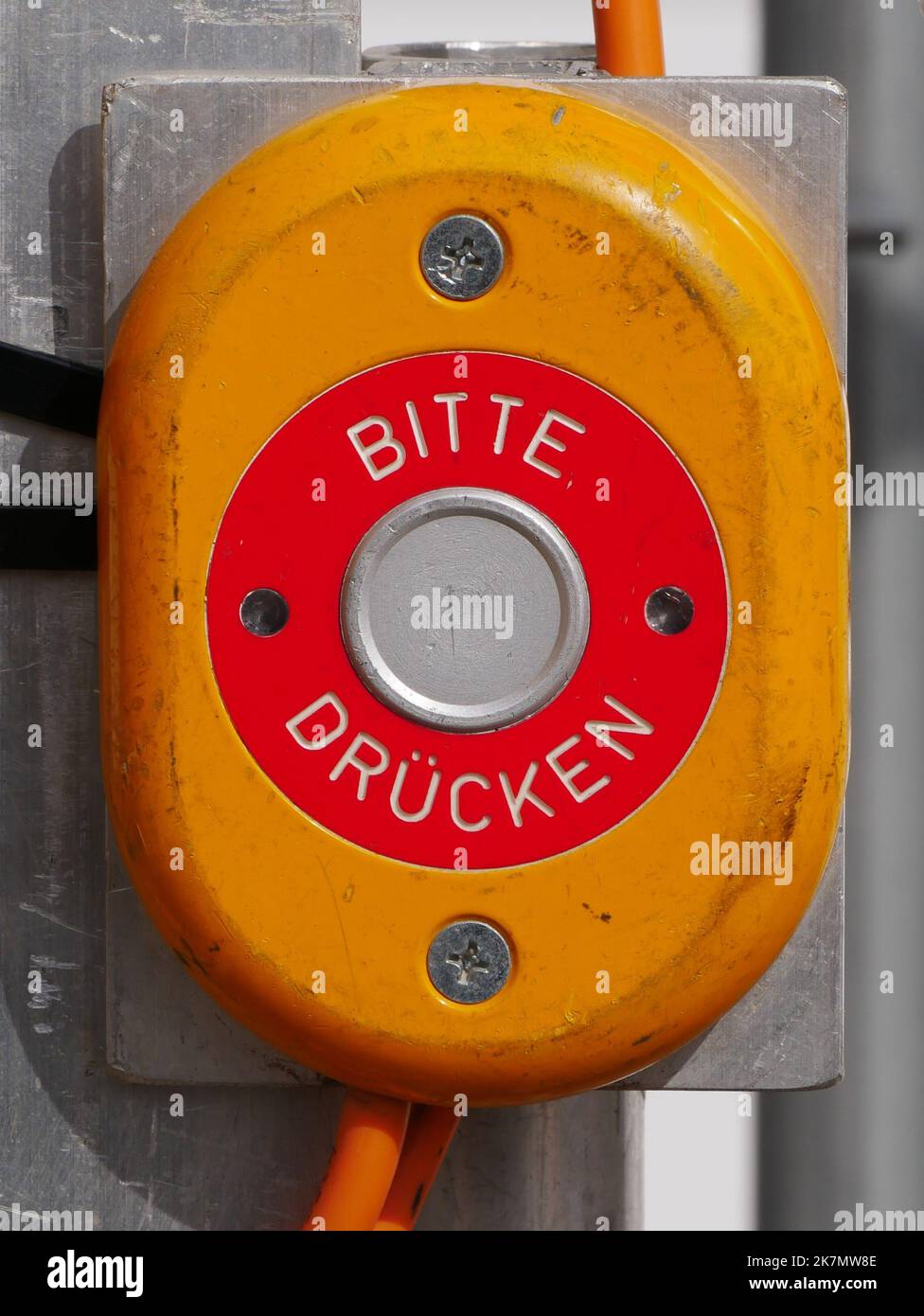 A red button with yellow background with a german text saying "please ...