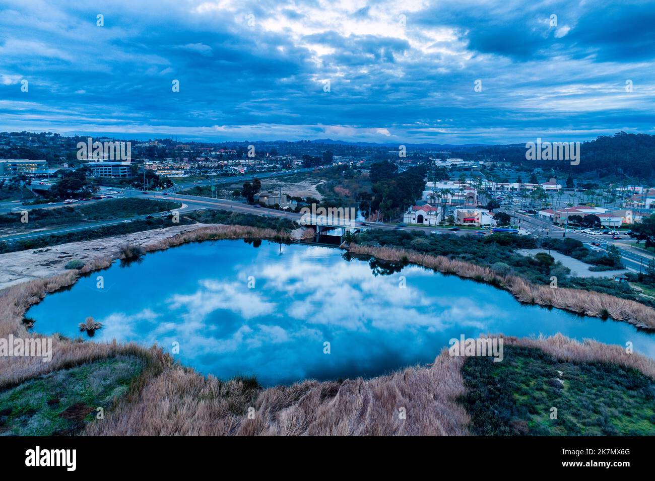 An arial shot of a round river surrounded by field and the city in the ...