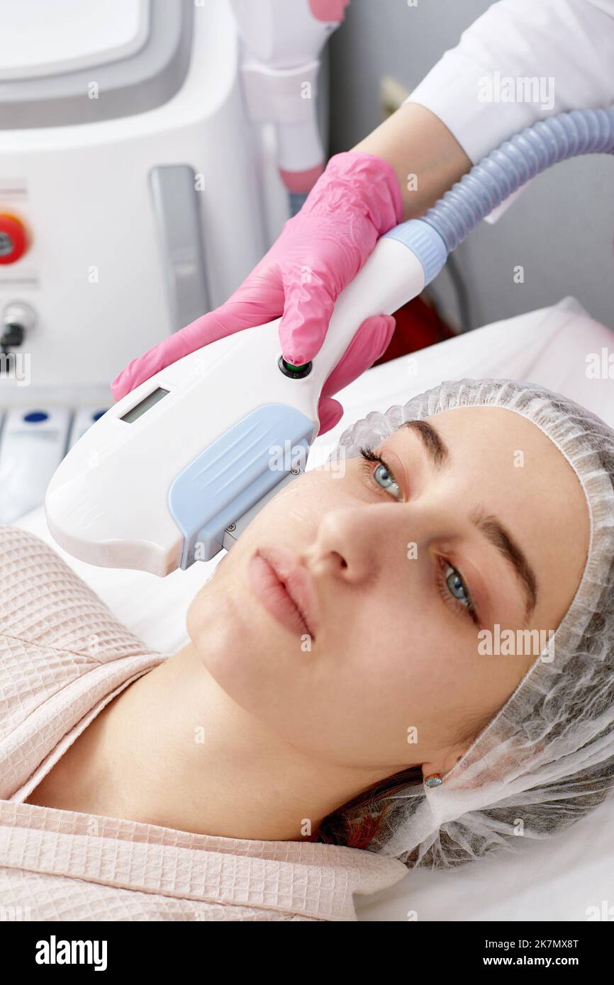 procedure of photoepilation in the beauty salon. Young Woman Receiving ...