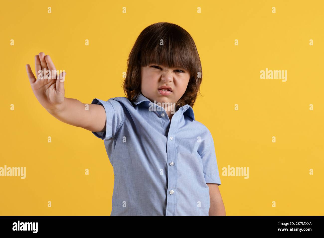 Disgusted little boy showing STOP gesture and frowning face, feeling ...