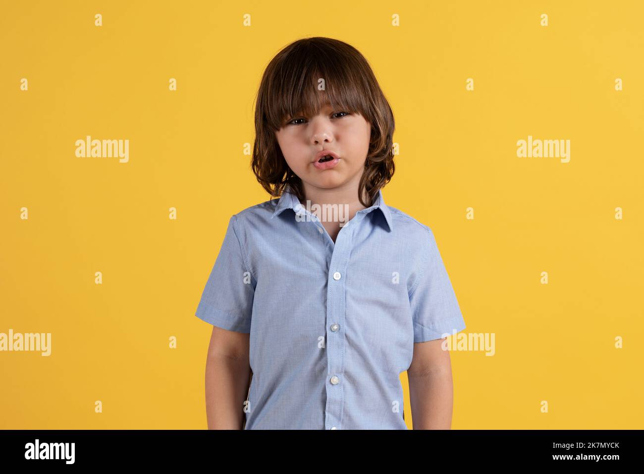 Kids unhappiness. Upset little boy pouting lips, looking at camera with ...