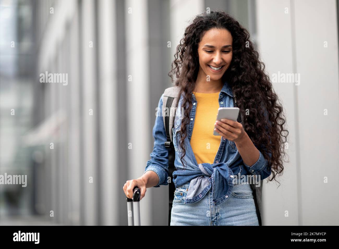 Happy middle eastern lady travelling alone, using smartphone Stock ...