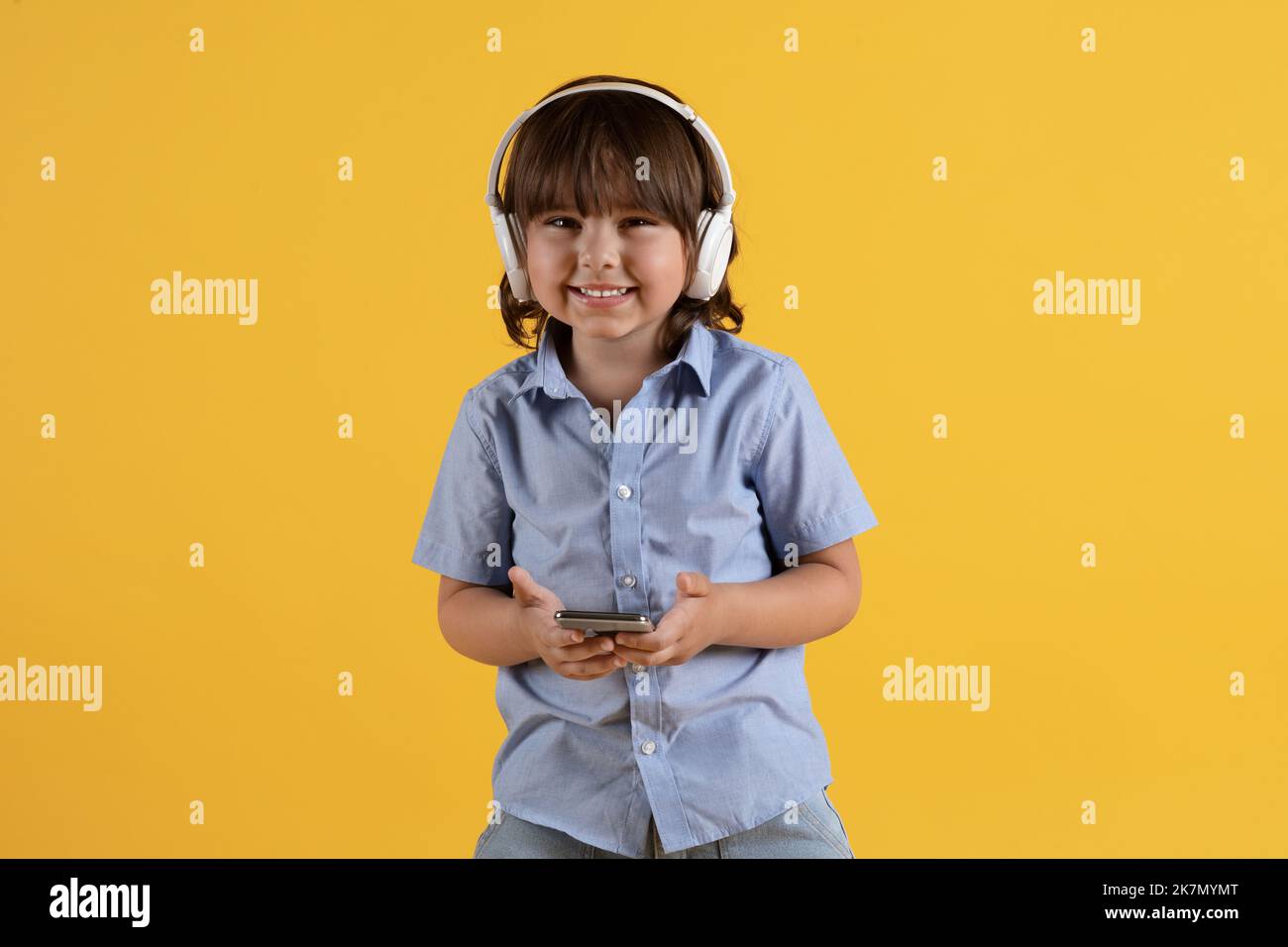 Happy little boy in wireless headset watching cartoons online on ...