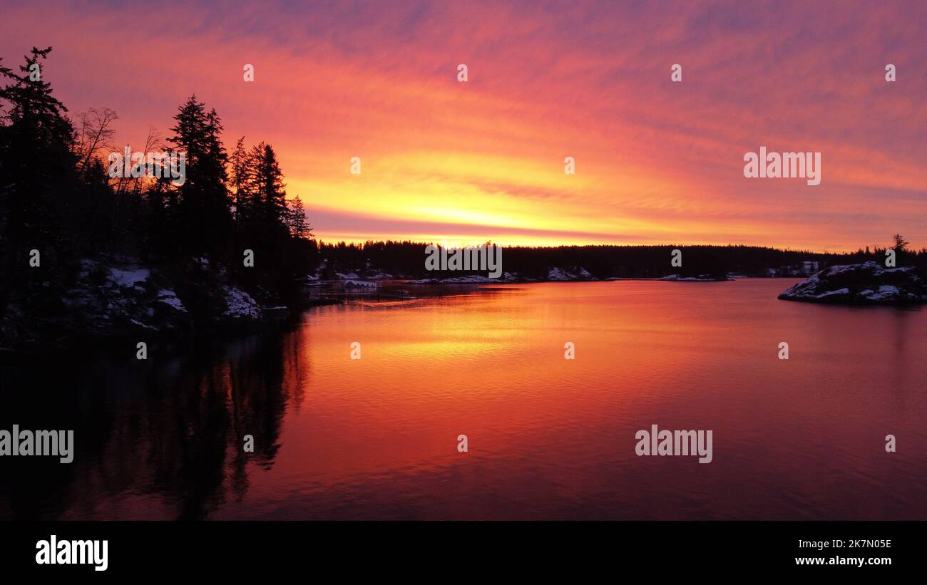 A beautiful shot of a golden sunset with a cloudy sky over a lake in ...