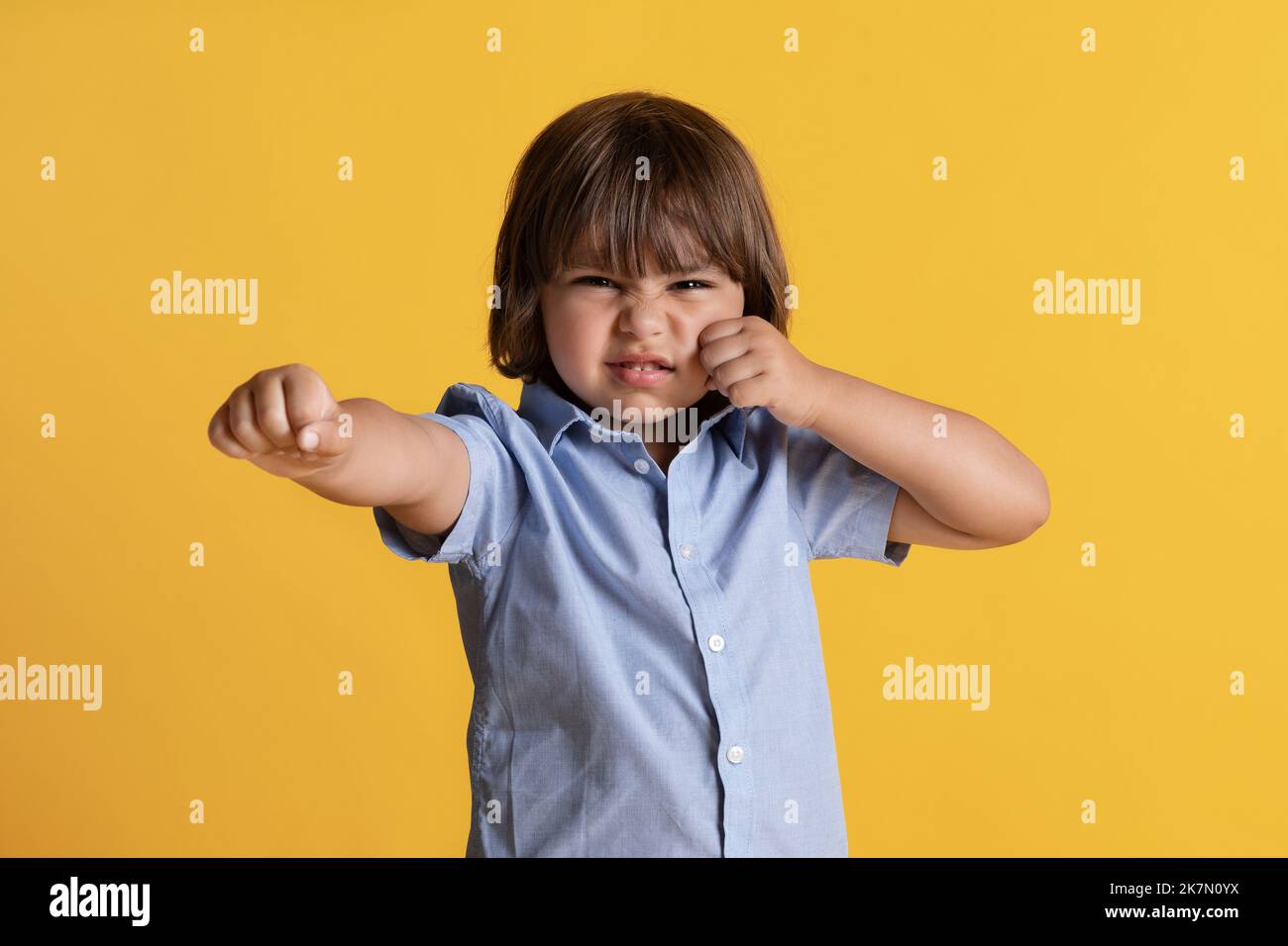 Kids anger and emotions. Furious little boy showing fists to camera ...