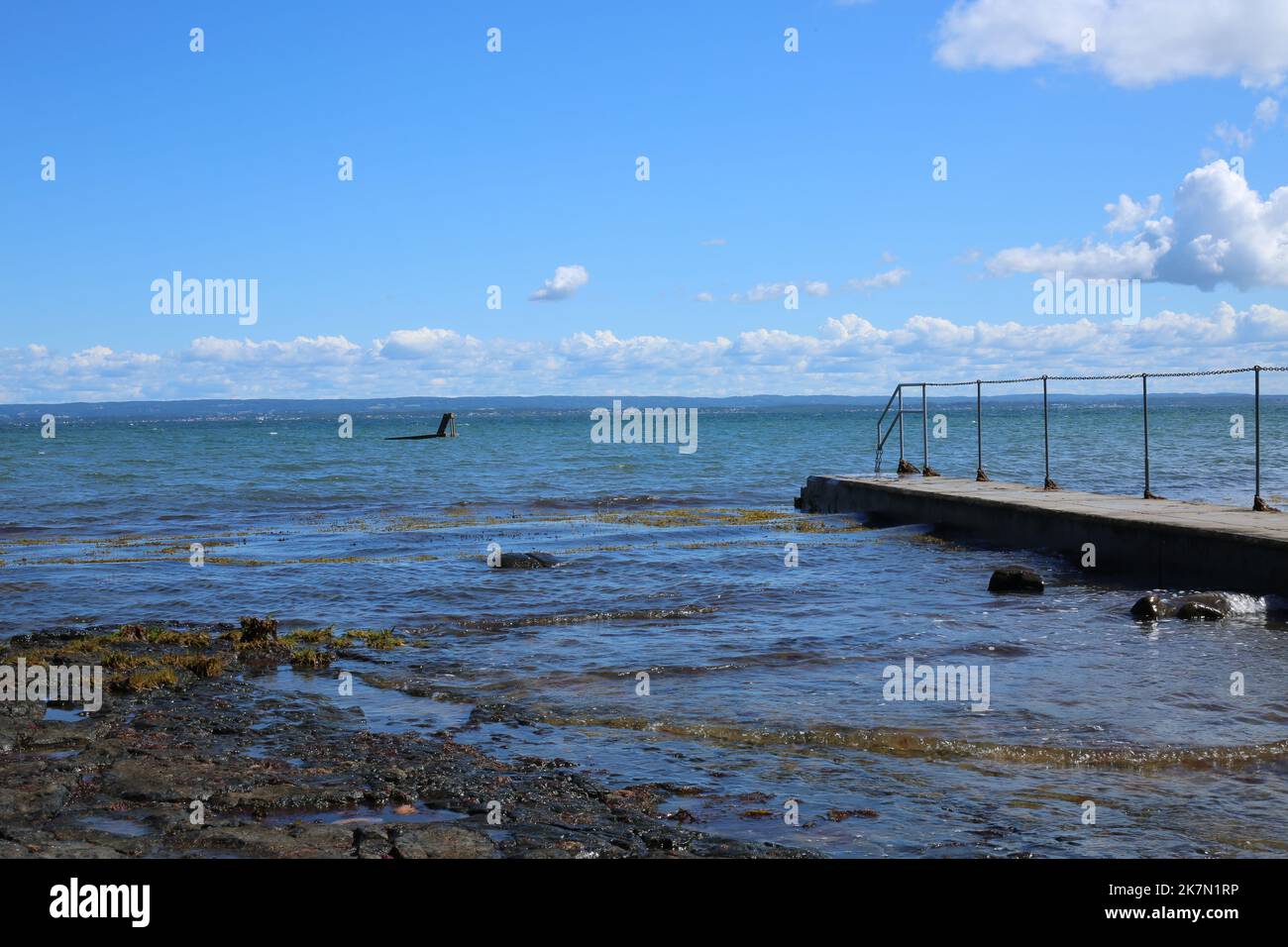 A beautiful seascape with a dock under a cloudy sky Stock Photo - Alamy
