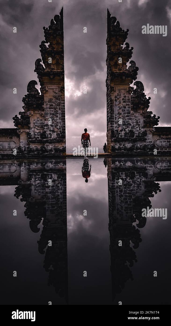 A vertical shot of a man between the gates of Lempuyang temple, with ...