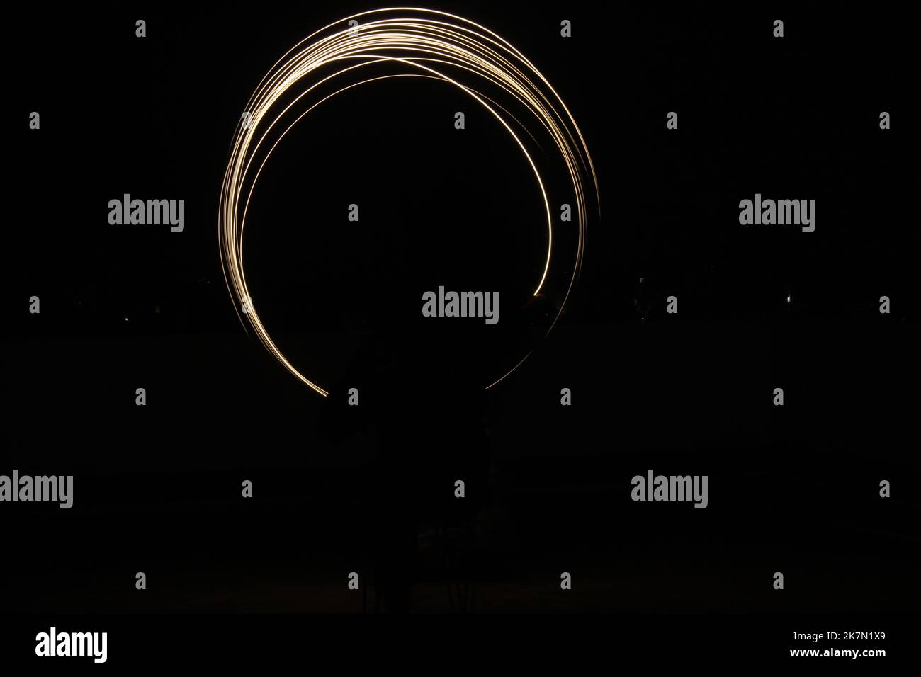 The long exposure of lights in a circular motion over the black ...