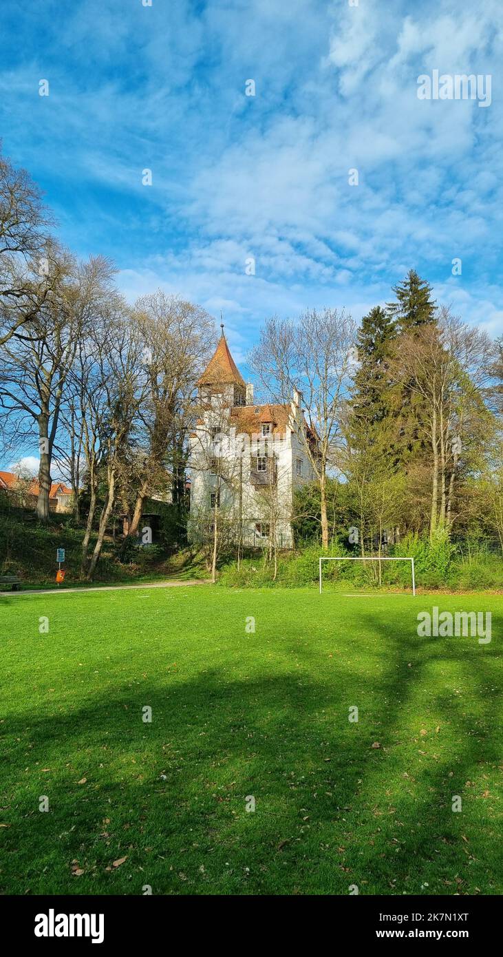 The vertical view of a church hiding in the trees by a soccer field ...