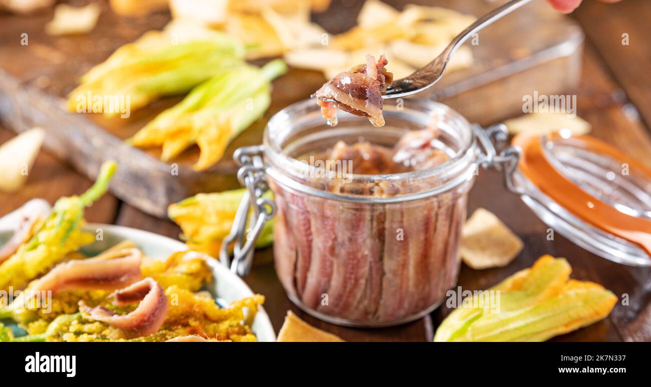 Anchovies in a jar, on a wooden rustic background. Traditional italian ...