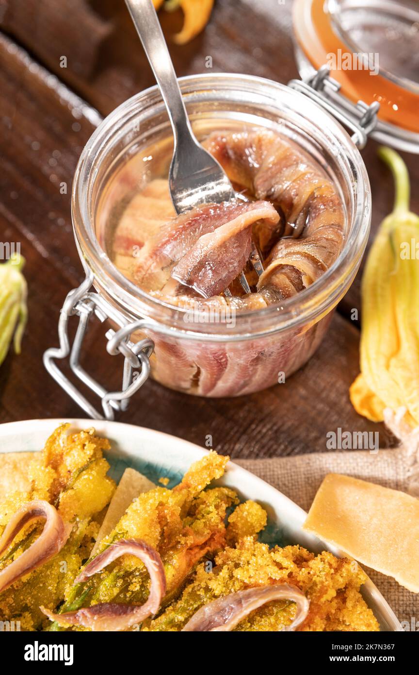 Anchovies in a jar, on a wooden rustic background. Traditional italian ...