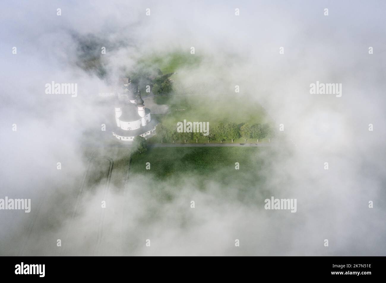An aerial view of the baroque church trinity covered by fog in the ...