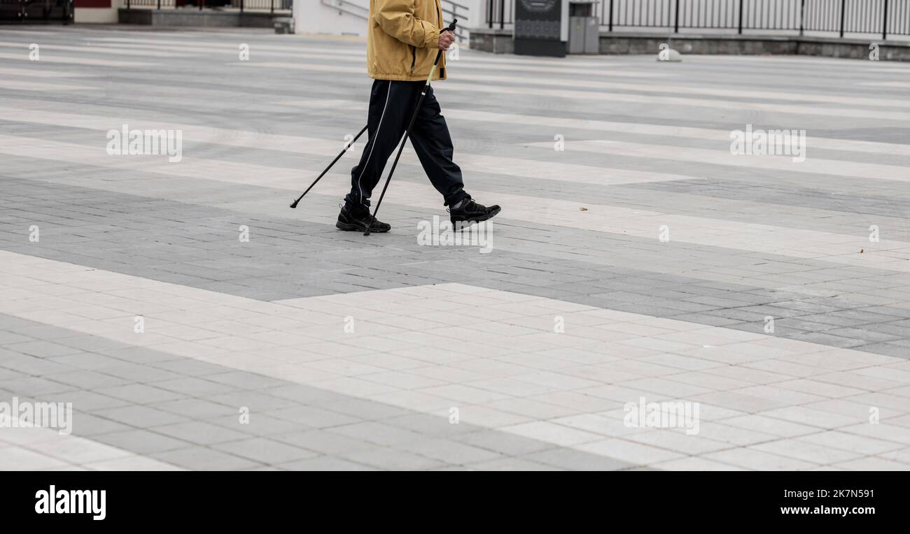 Adult man on a walk is engaged in Scandinavian walking. Leisure ...