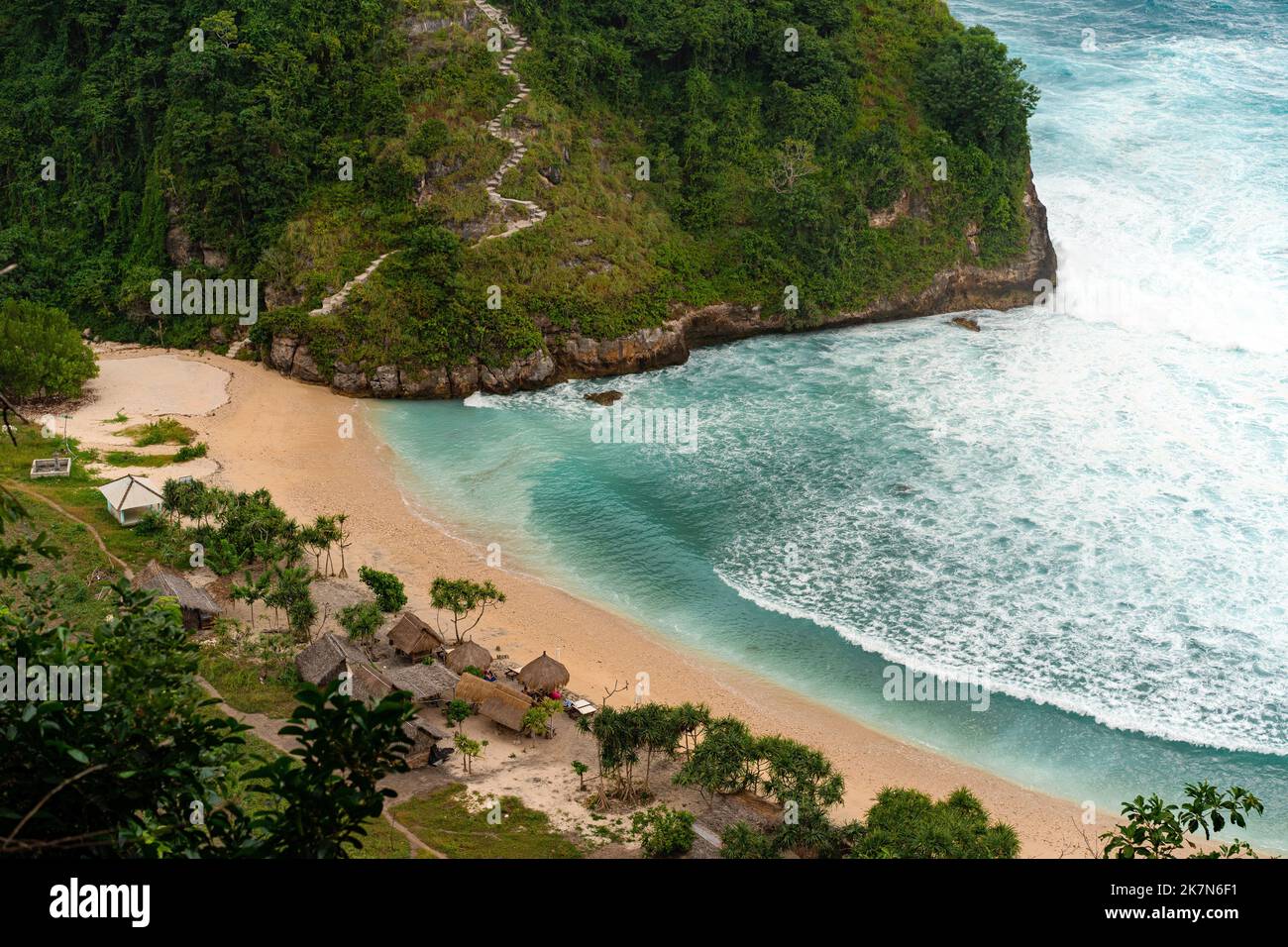 An aerial of Nusa Penida beach with green trees around and seascape ...