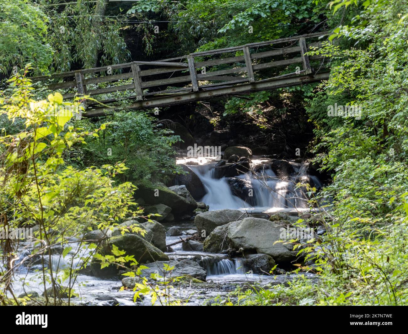 An old, decrepit bridge over rapids in the Hinata river in Isehara ...