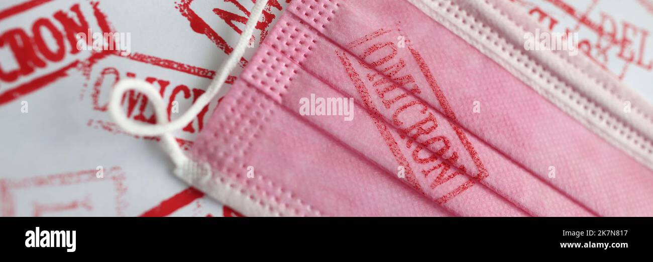 Red omicron stamp on a pink mask, close-up Stock Photo - Alamy