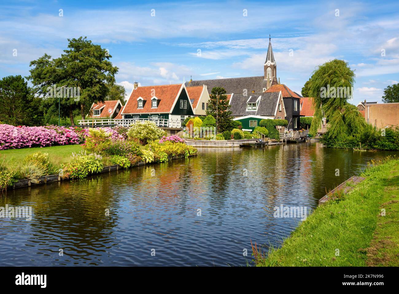 Traditional red tile roofed waterside houses on a river in picturesque ...