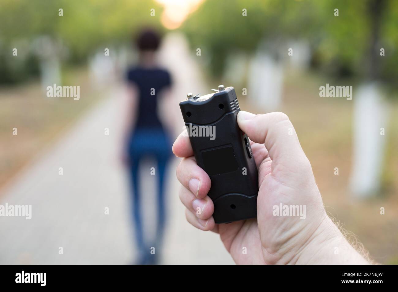 A man with stun gun chases a woman to rob Stock Photo - Alamy