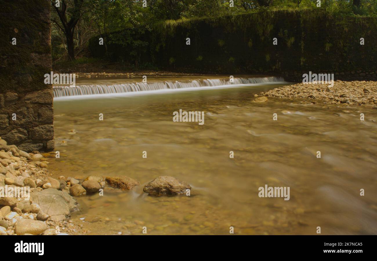 View of the flow in canal joining with the river, long exposure picture ...