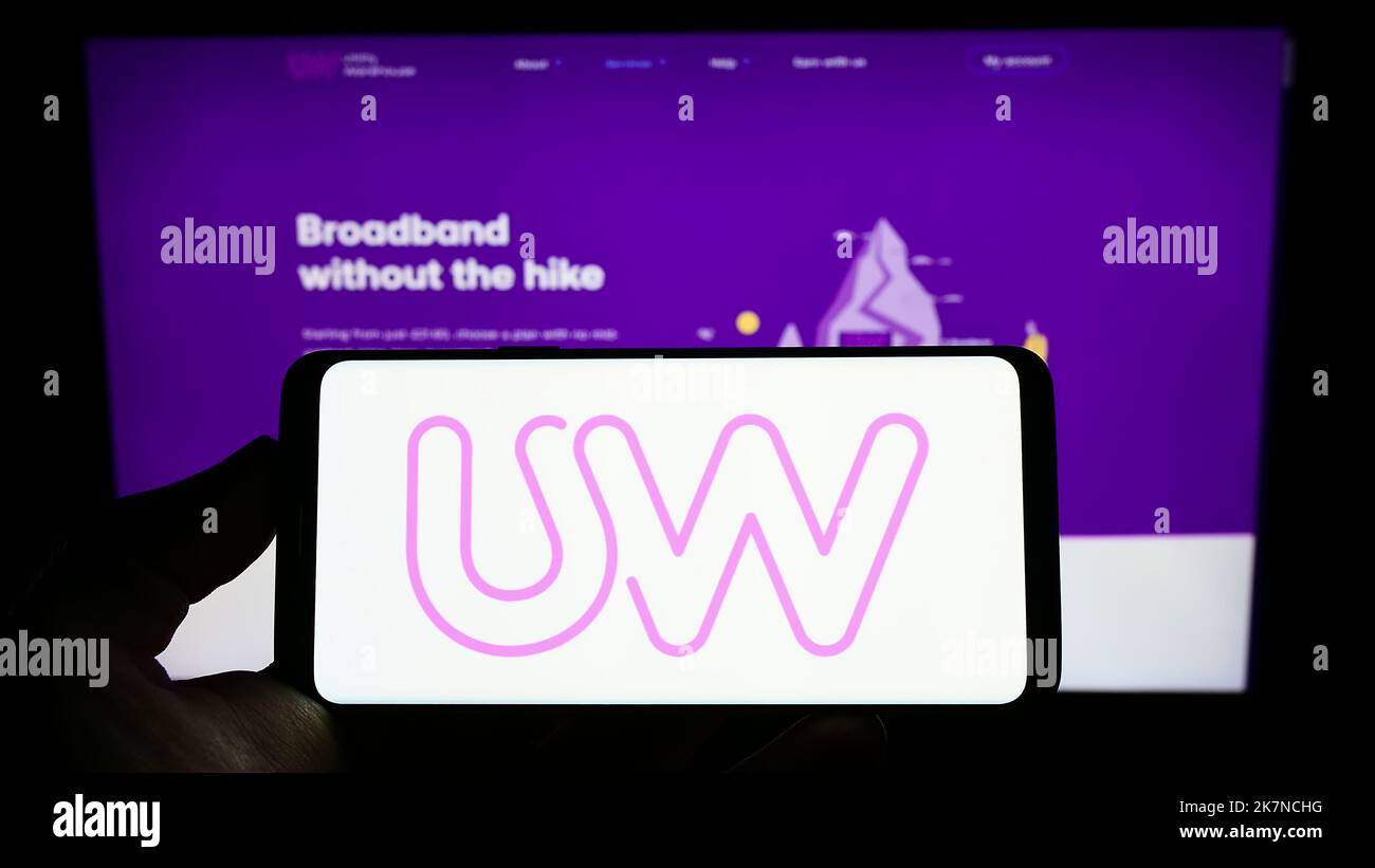 Person holding mobile phone with logo of British company Utility ...