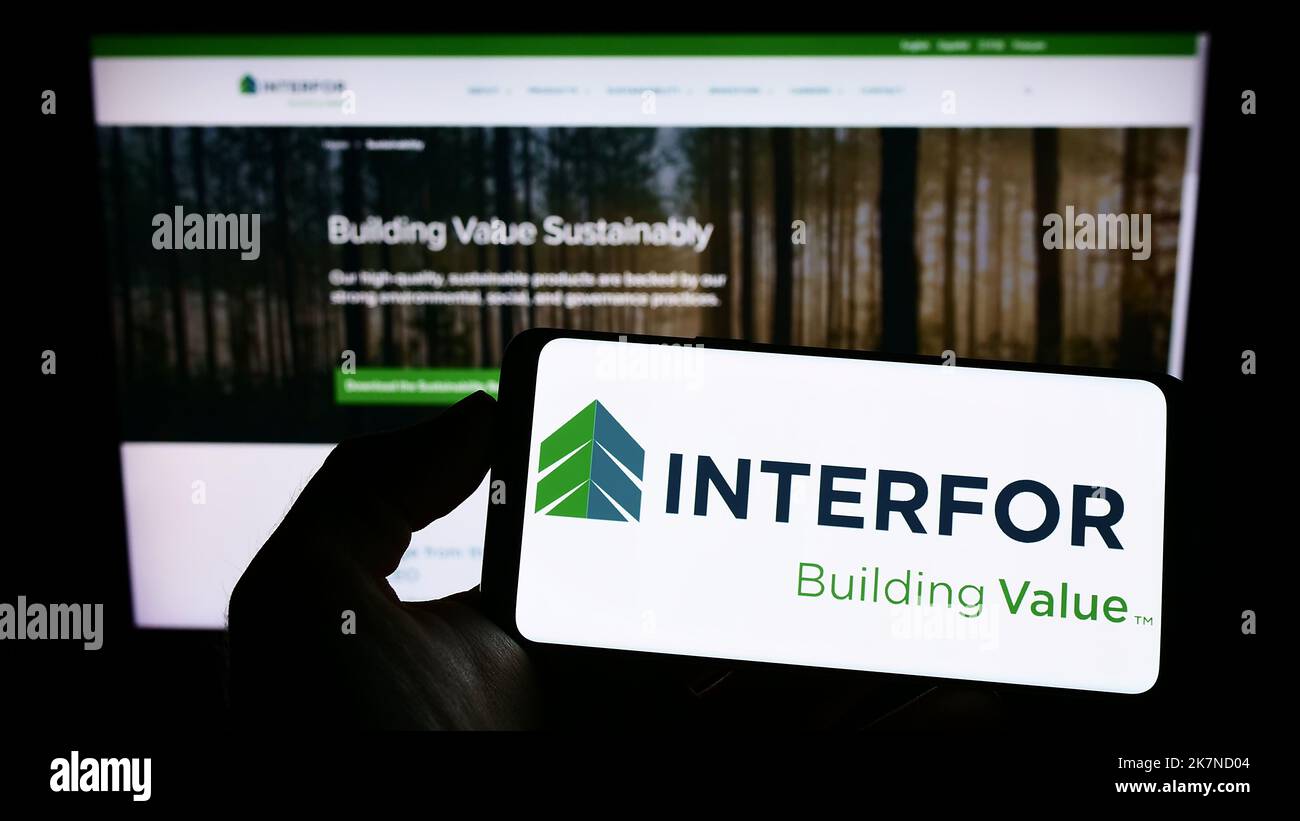 Person holding mobile phone with logo of Canadian forestry company ...