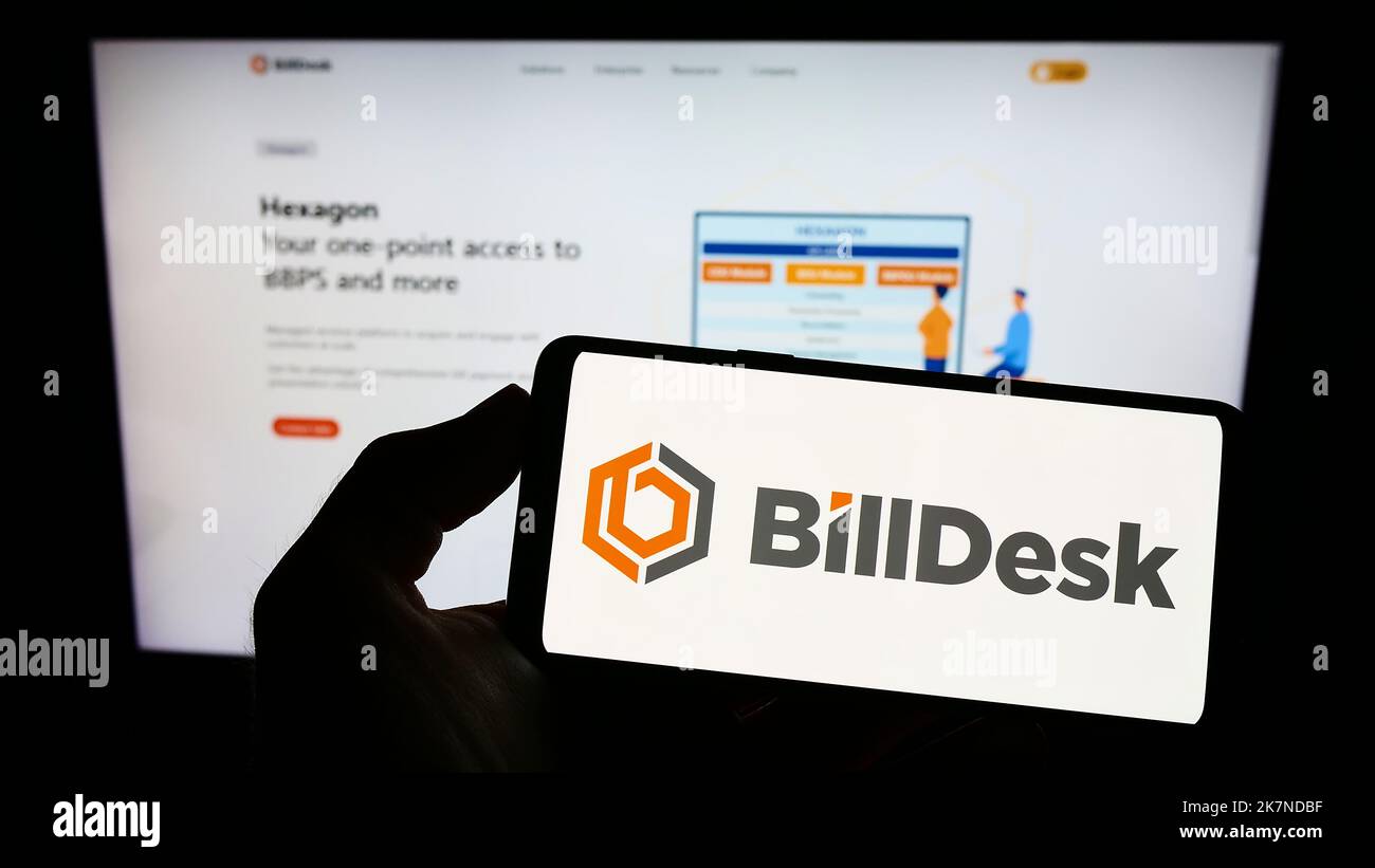 Person holding mobile phone with logo of Indian company IndiaIdeas.com Limited (BillDesk) on ...