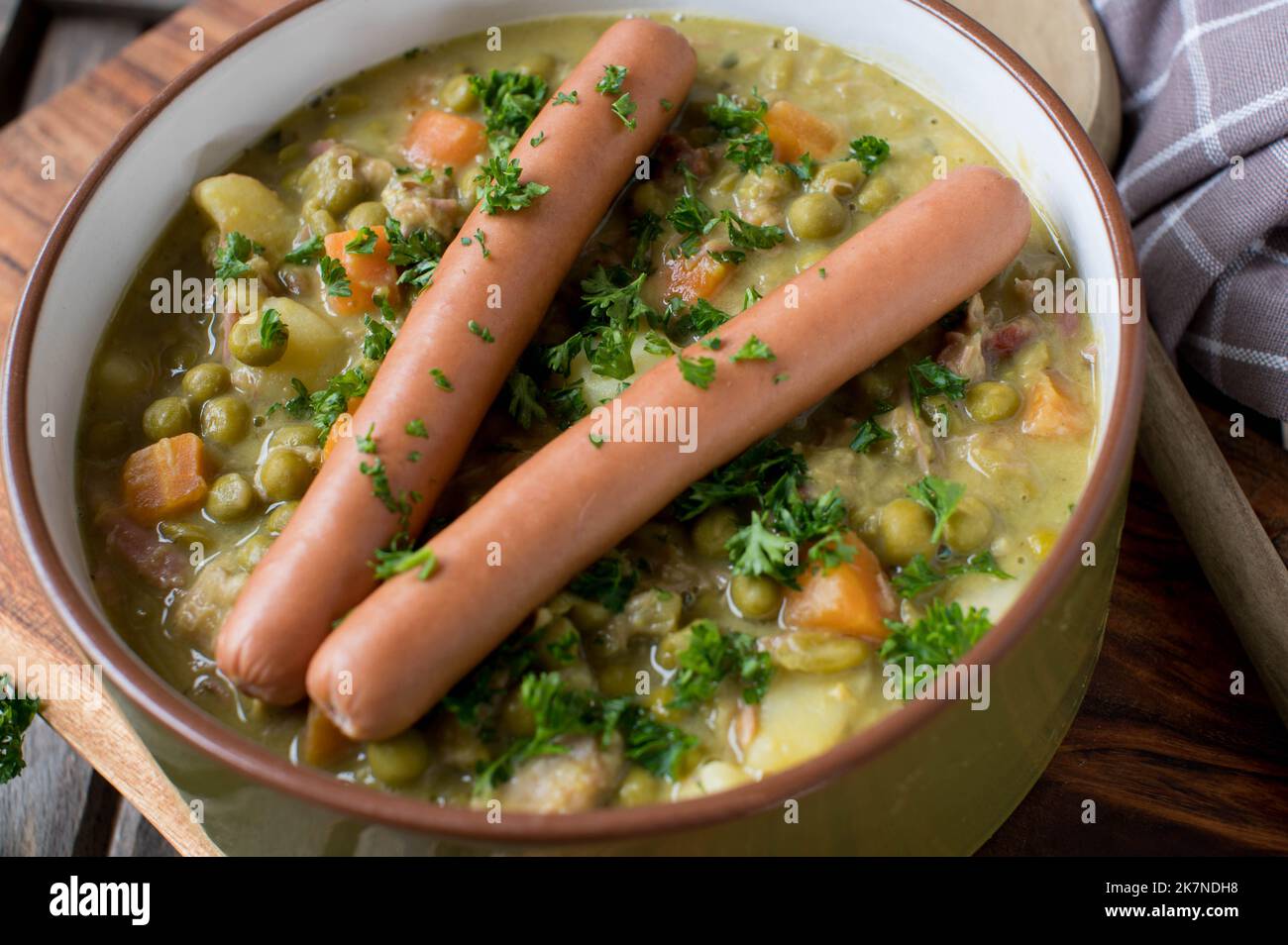 Pea stew with vienna sausage in a old fashioned bowl on wooden ...