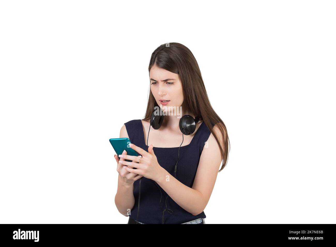 Puzzled young woman with headphones looking confused at her smartphone ...