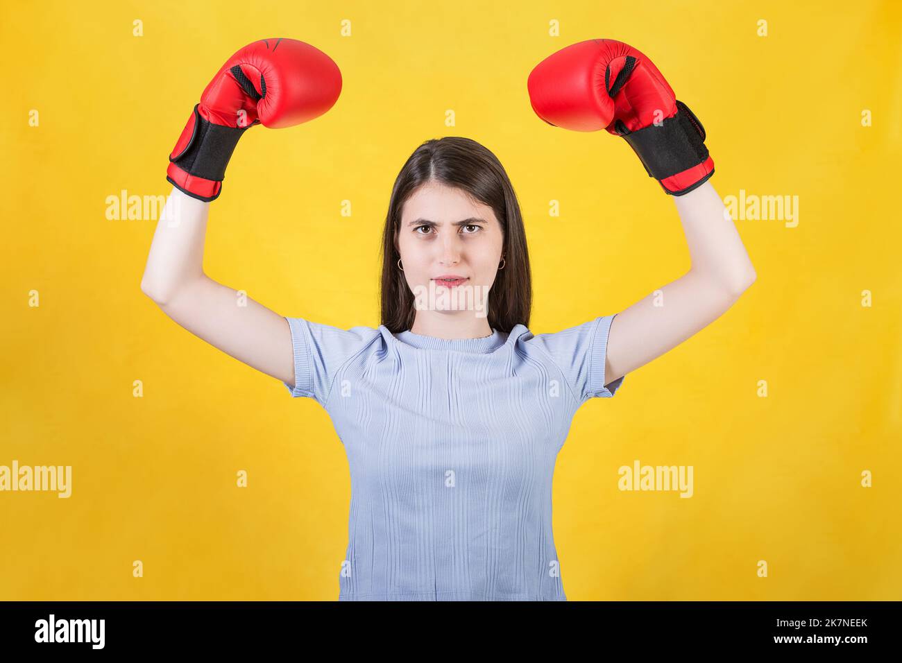 Confident young woman with red boxing gloves celebrating success ...
