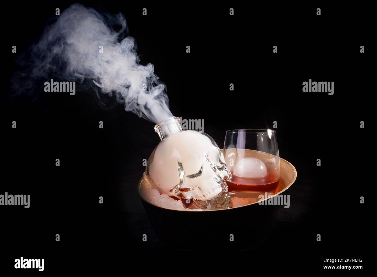 A bottle in the form of a skull with a cocktail and a stream of smoke ...