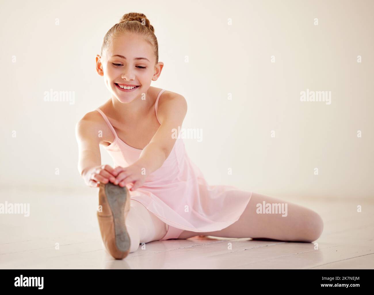 It takes an artist to be a dancer. a young ballerina stretching on the ...