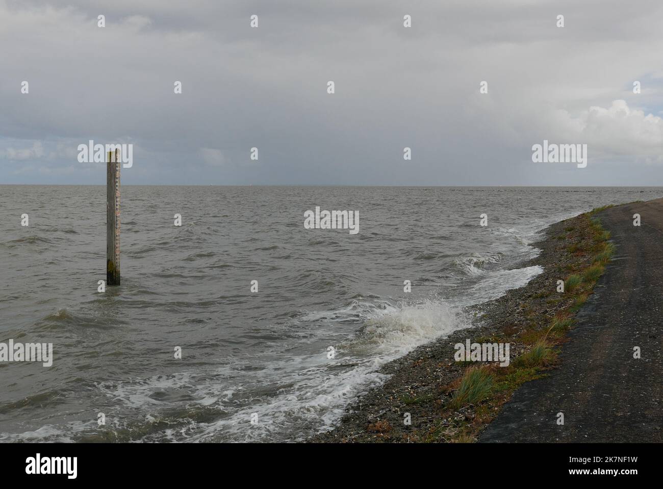 Sea defences and tide depth measuring pole. Wadden Sea. Neatherlands ...