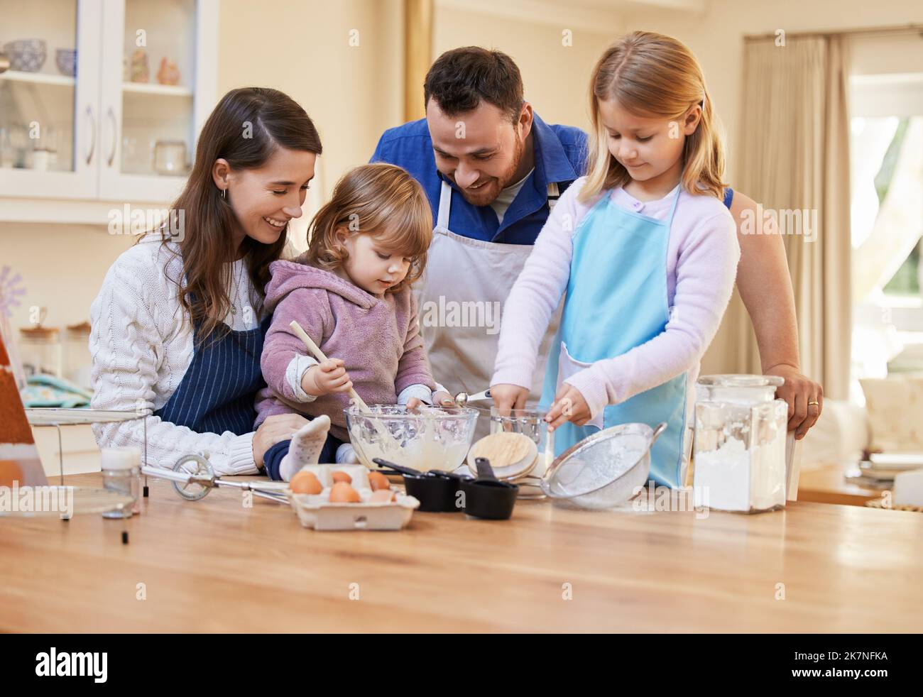 Helping our girls build a bond. a family baking together while a little ...