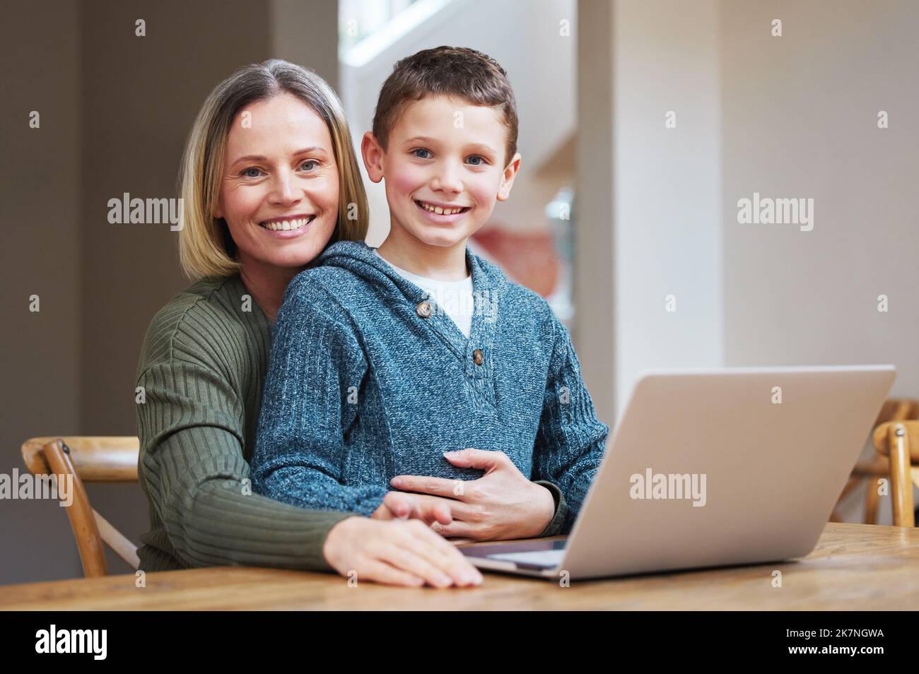 Together we can do anything. a mother helping her son complete his homework using a laptop Stock ...
