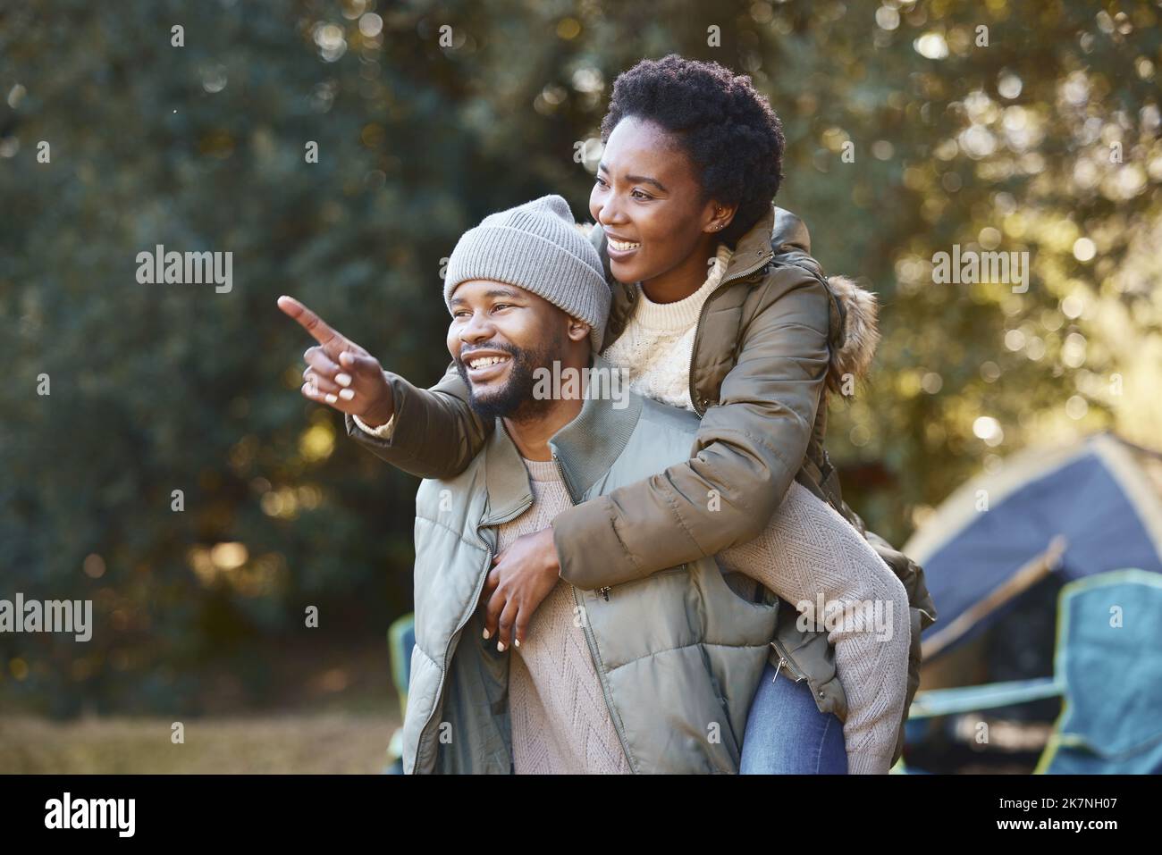 Lets go see what that is. a young man giving his wife a piggyback ride ...
