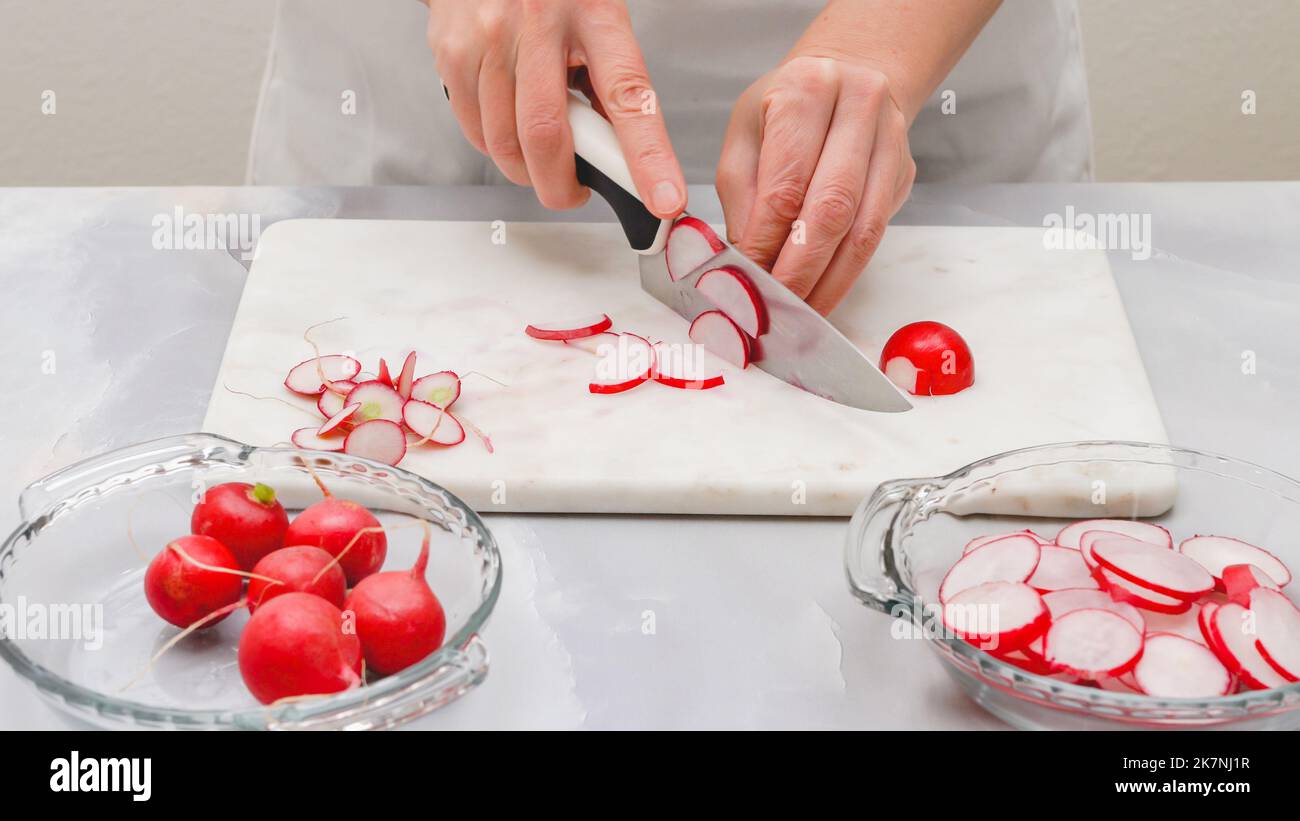 Fresh sliced radish close up on marble cutting board on light grey ...