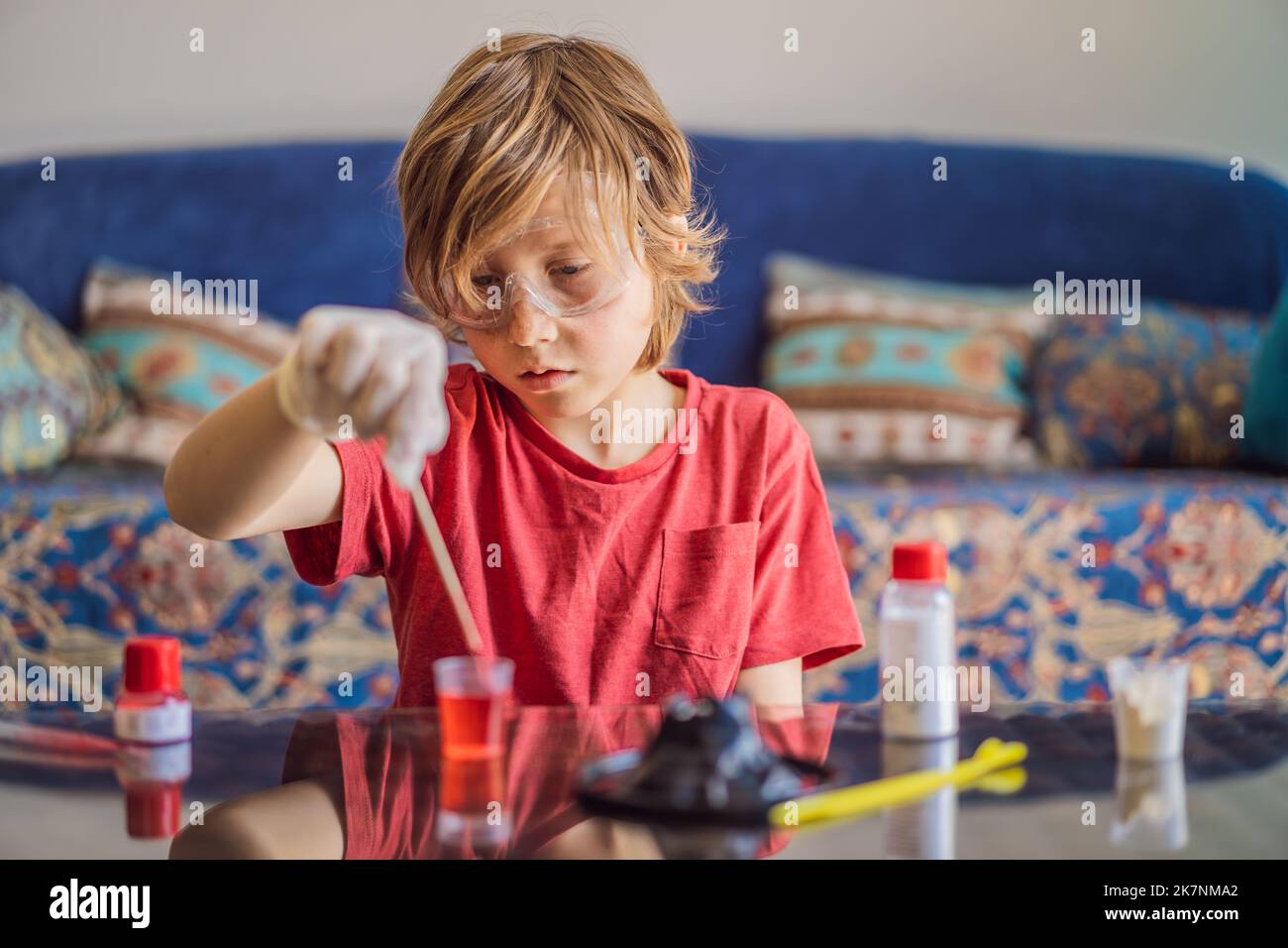 Kid boy doing chemical experiment at home. Child with protective ...