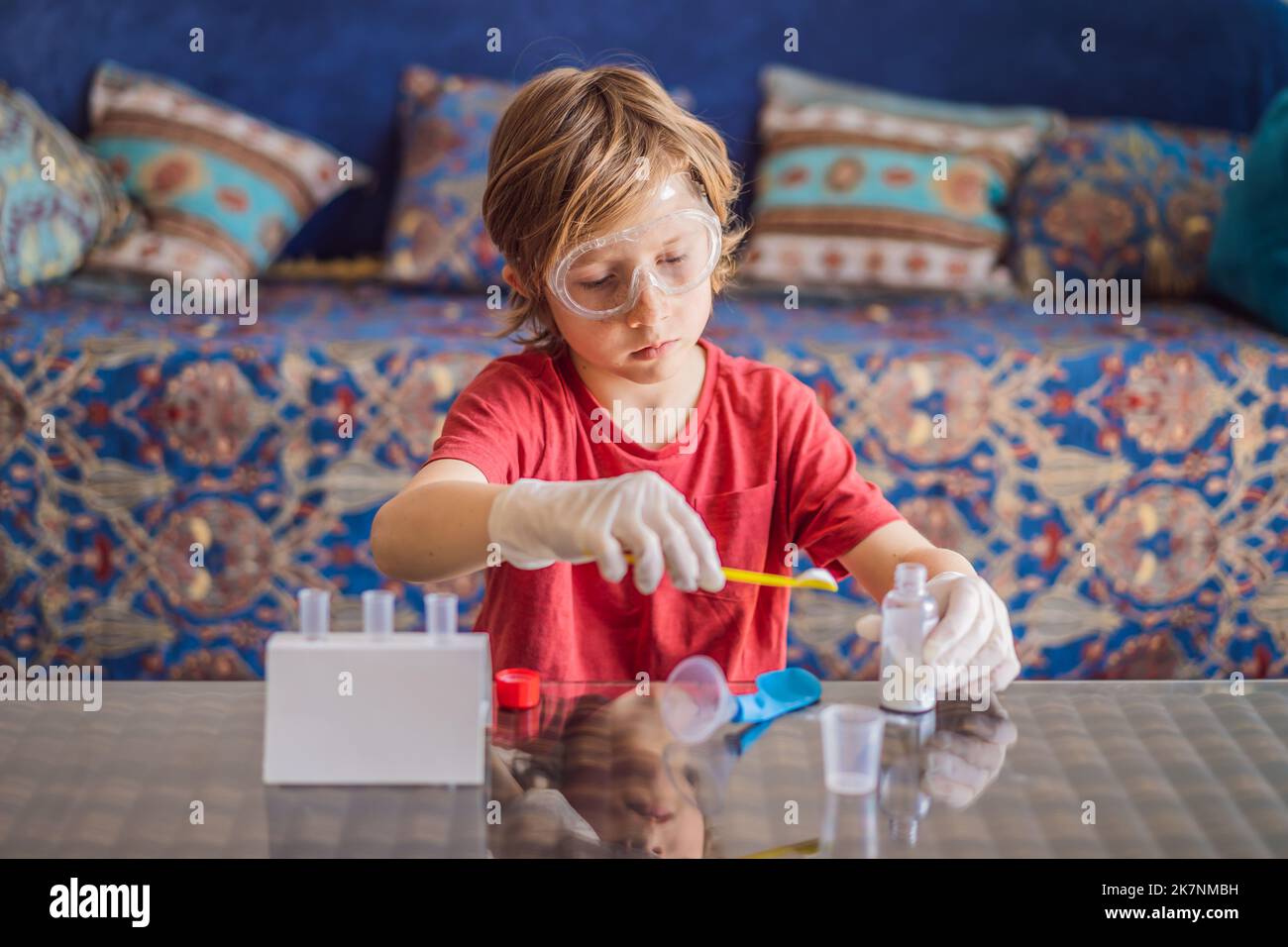 Kid boy doing chemical experiment at home. Child with protective ...