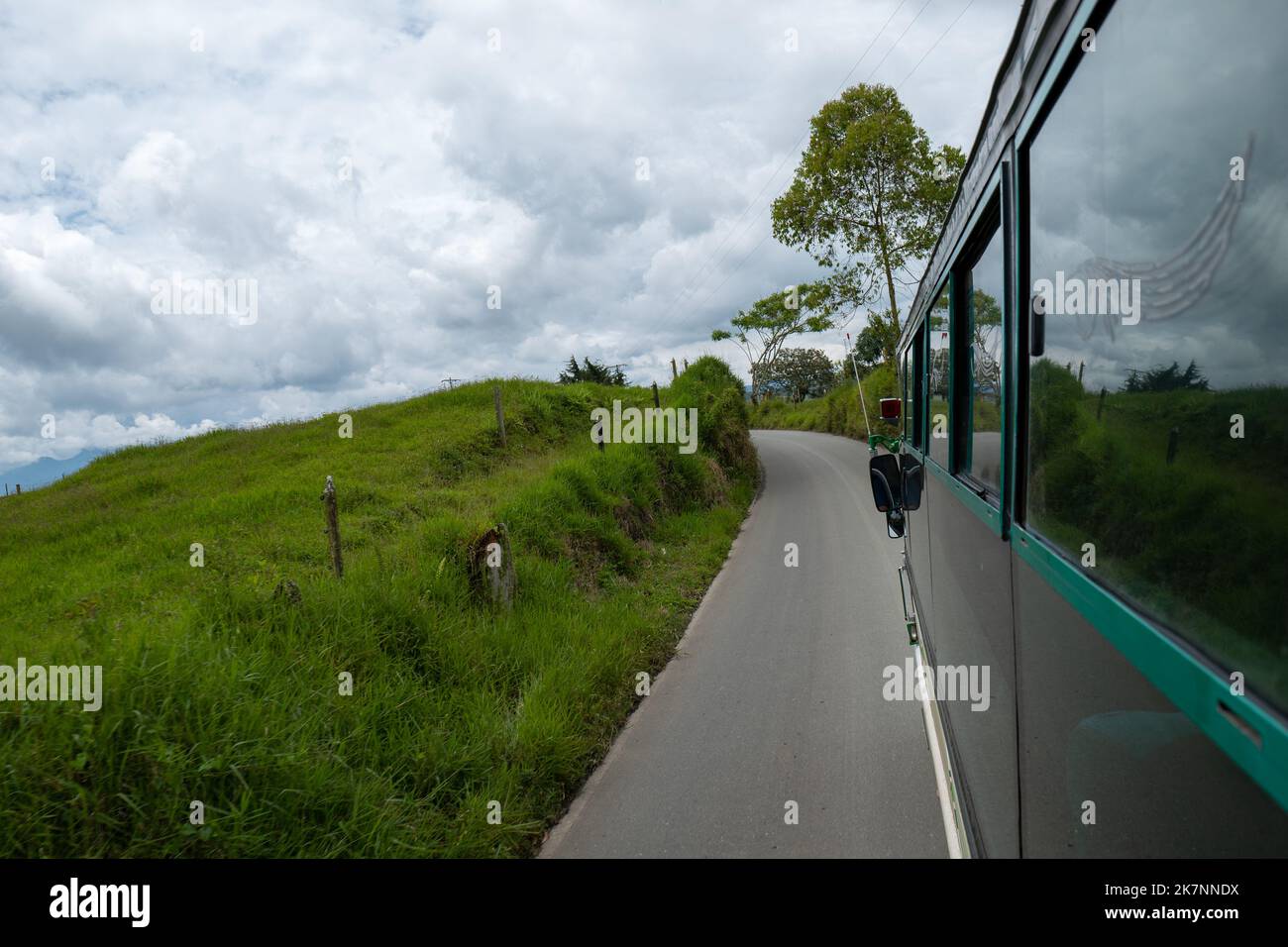 Bus Passing Along an Asphalt Road Next to a Green Field Stock Photo - Alamy