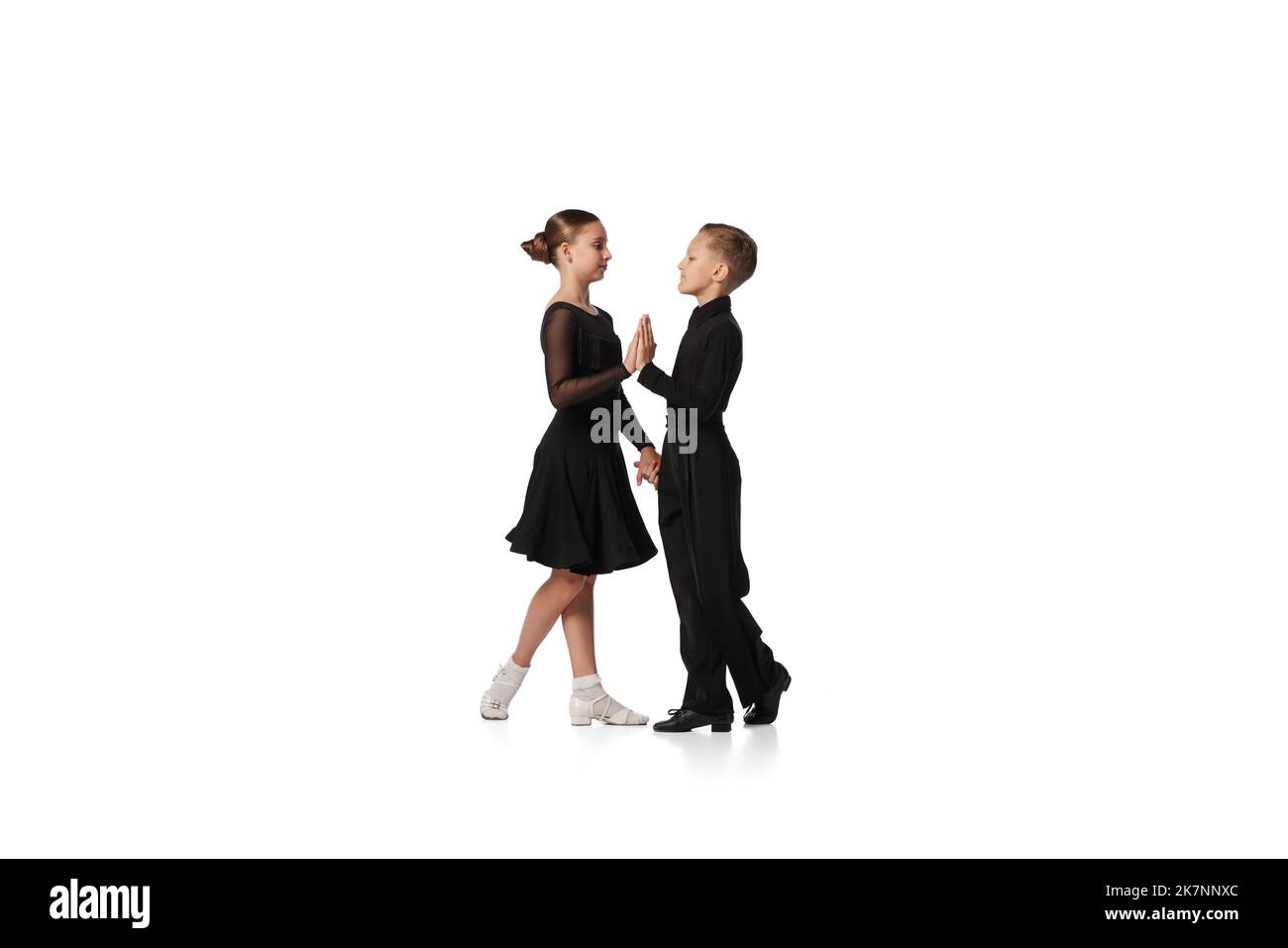 Two kids, school age girl and boy in black stage costumes dancing ...