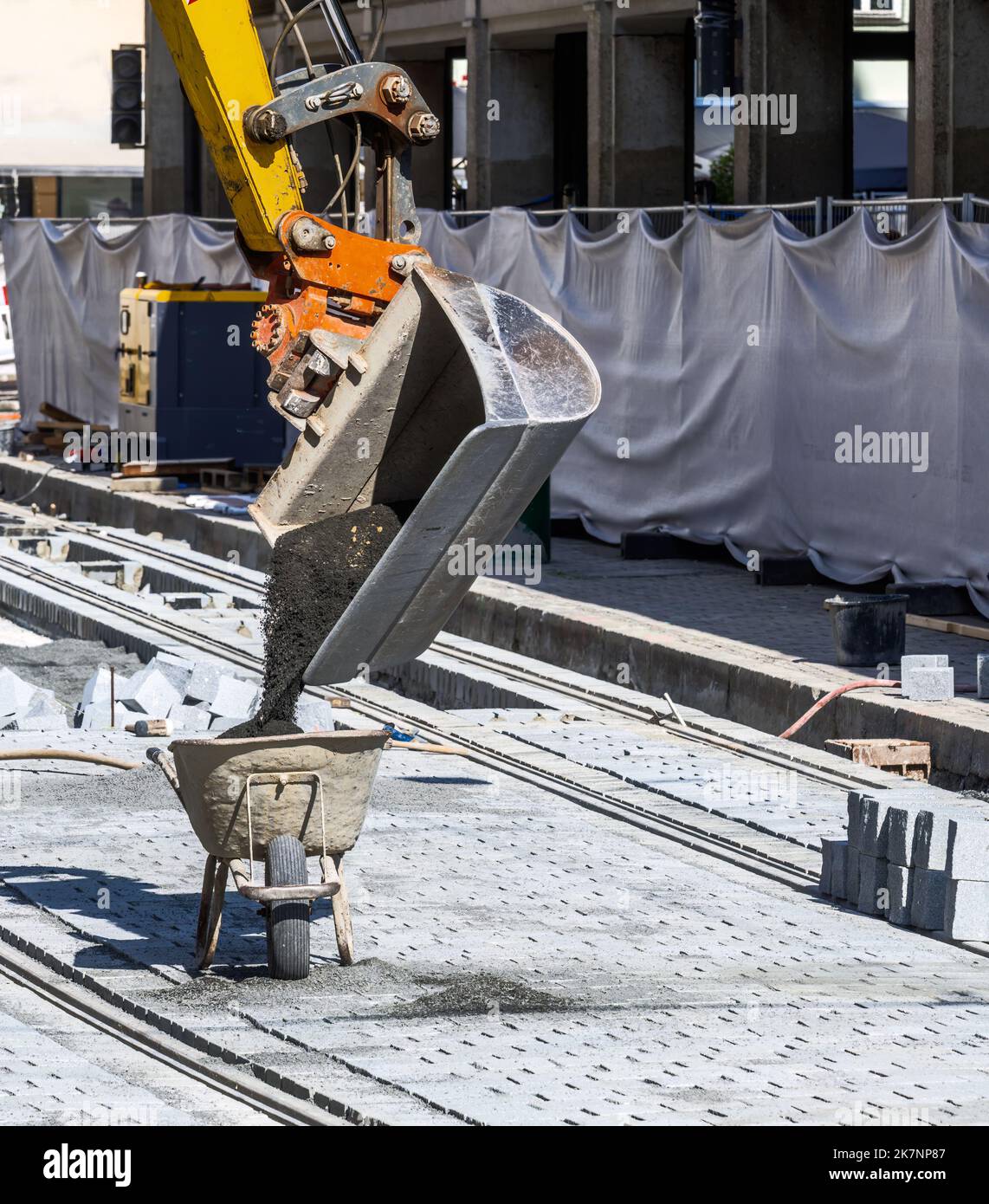 Excavator filling sand in a wheelbarrow on a constructin site Stock ...