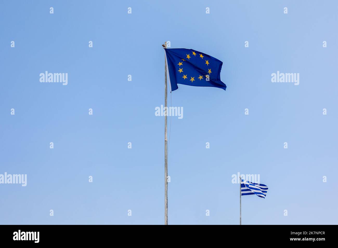 European Union EU and Greece flags is flying in air on blue sky ...