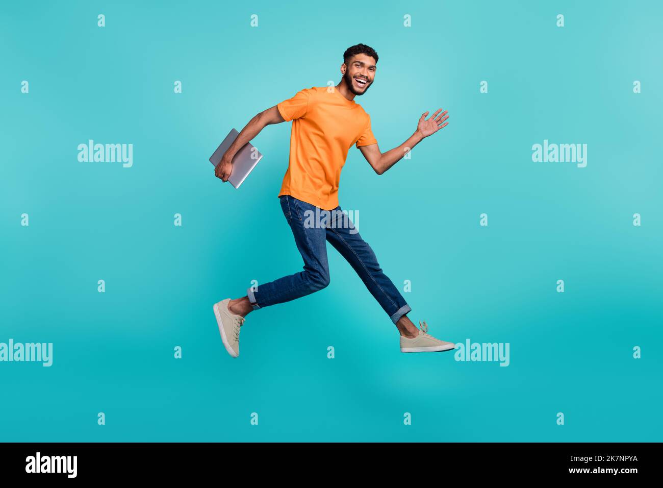 Full size profile photo of excited active man jump rush fast hold ...