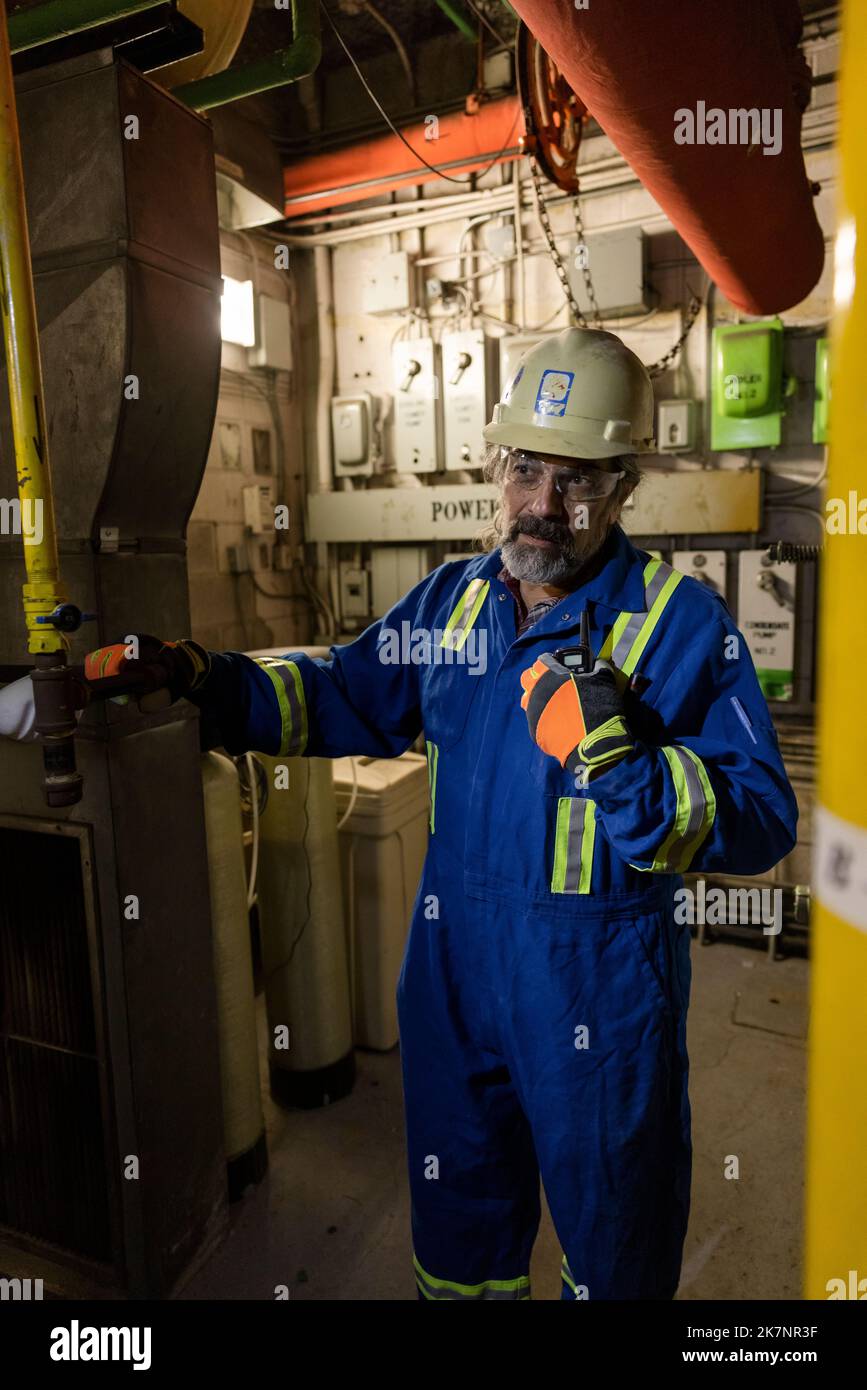 Construction worker in electrical control room of outdated building ...