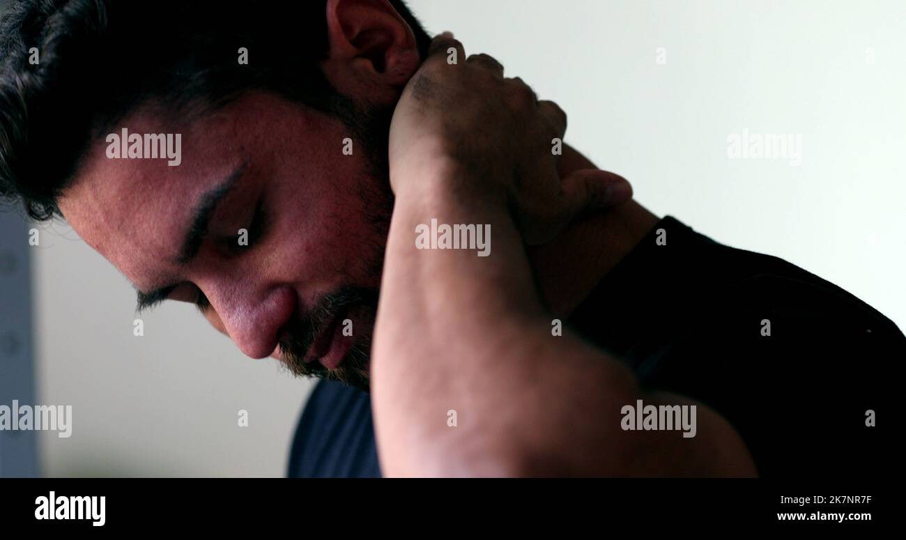 Anxious man touching face and neck in frustration Stock Photo - Alamy