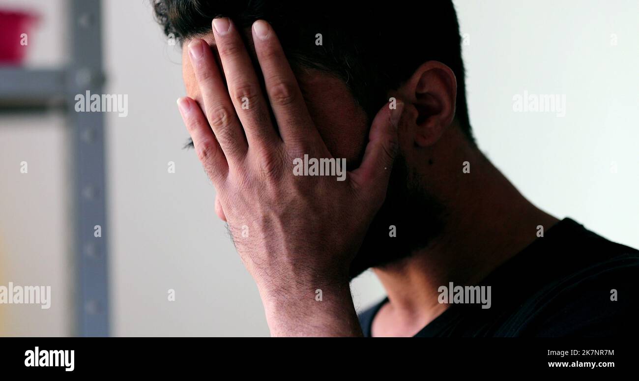 Anxious man touching face and neck in frustration Stock Photo - Alamy