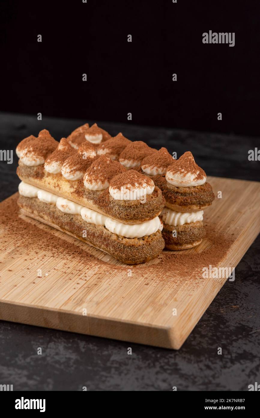 Dessert Tiramisu cake on a tray on a dark background in a coffee shop ...