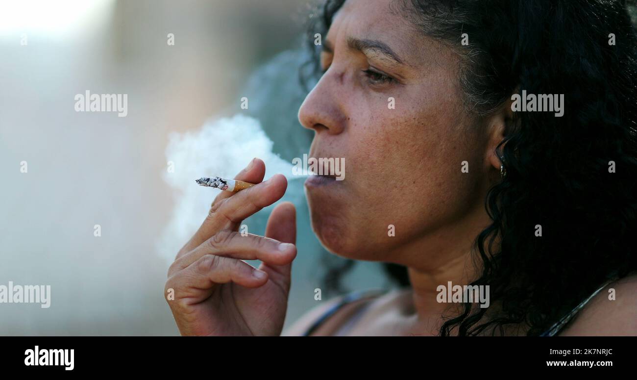 Hispanic anxious woman smoking cigarette Stock Photo - Alamy
